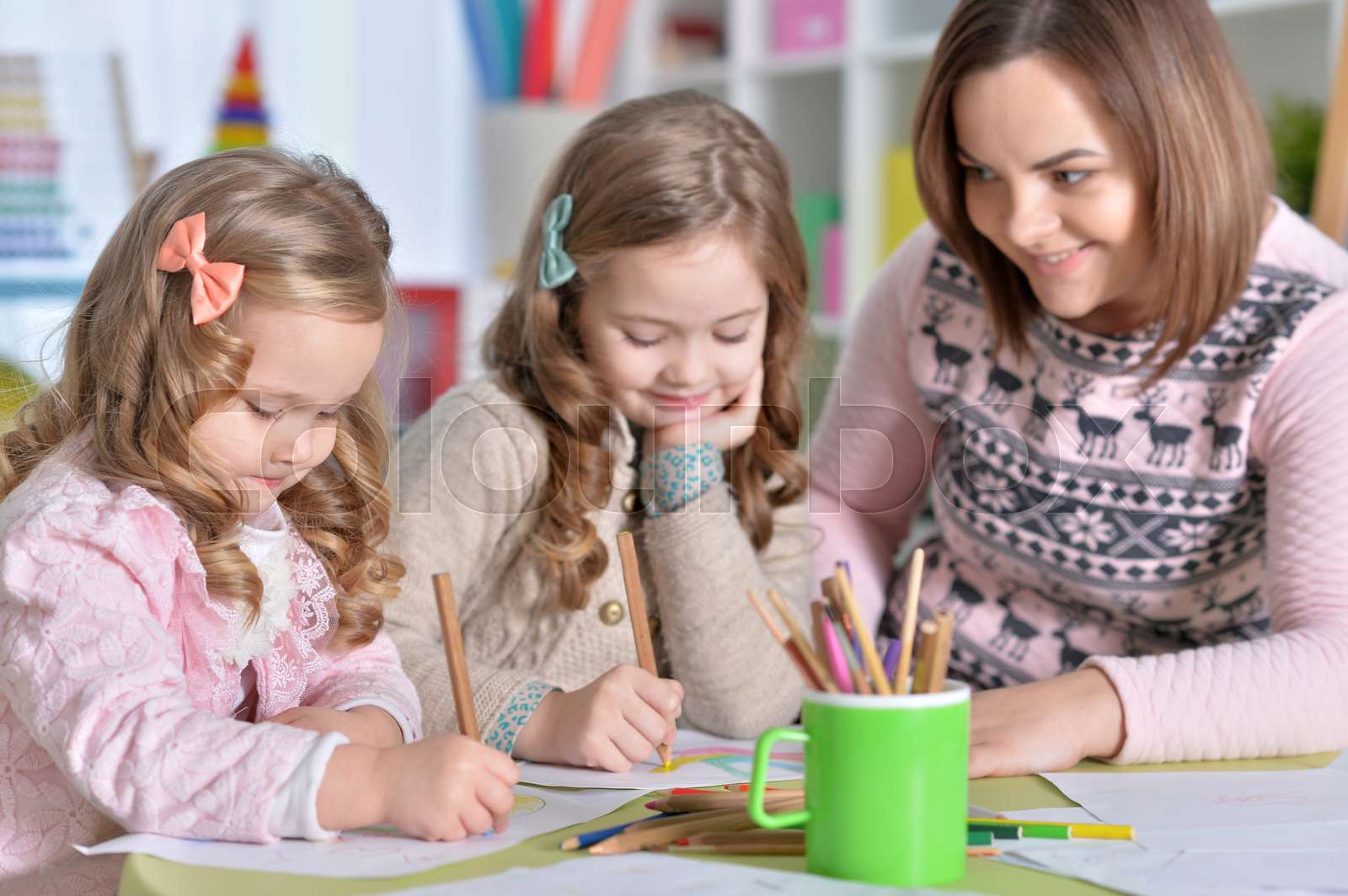 Mother and her two daughters drawing | Stock image | Colourbox