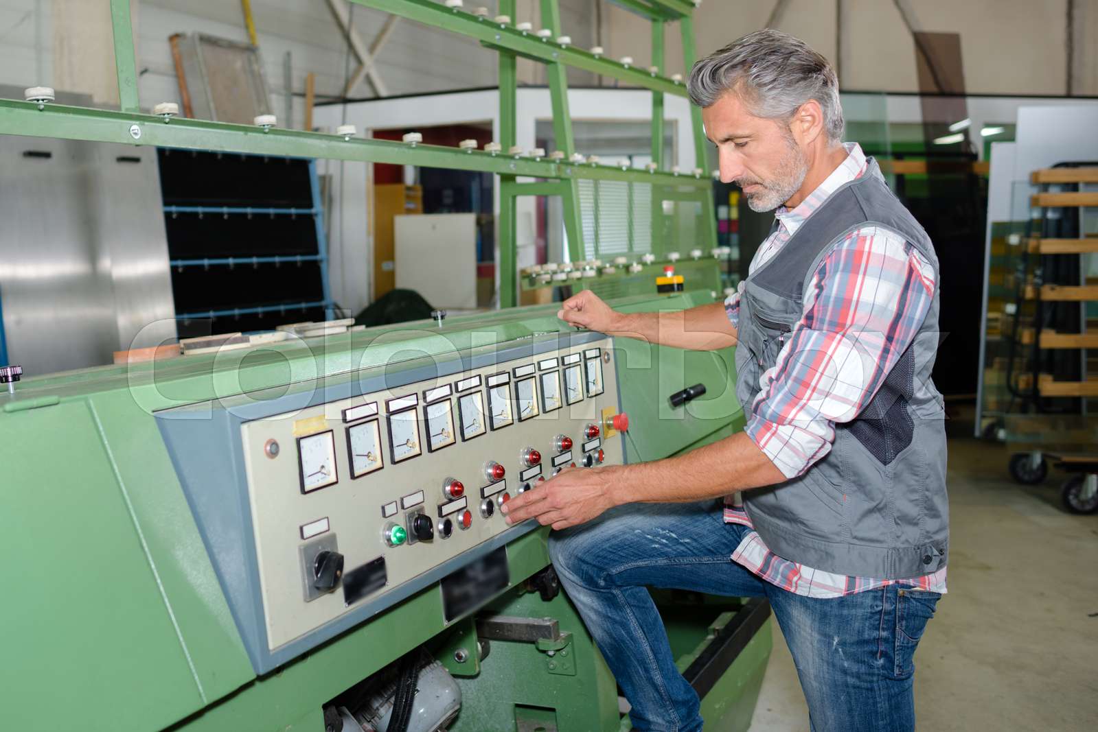 Mature man operating industrial machine | Stock image | Colourbox