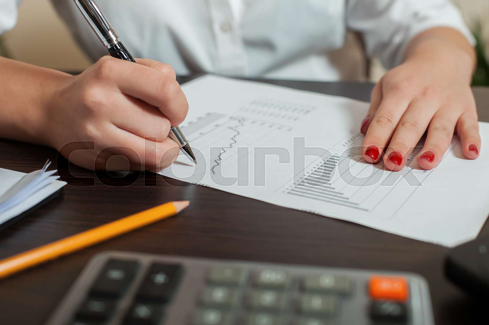 Bookkeeper signs accounting balance sheet | Stock image | Colourbox