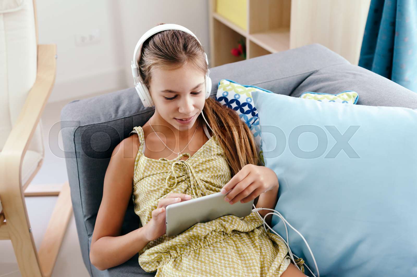 Tween girl relaxing on couch at home | Stock image | Colourbox