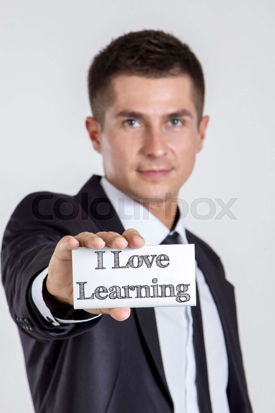 I Love Learning - Young businessman holding a white card with text ...