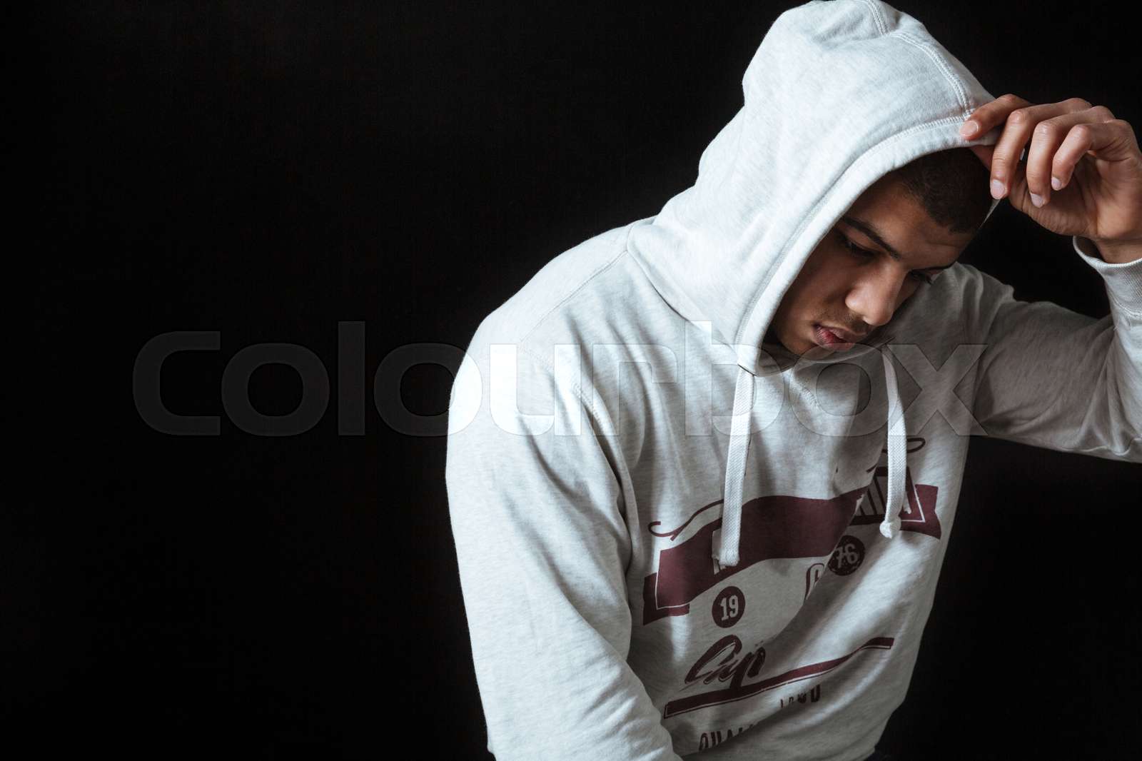 Sad disappointed african young man in hoodie standing and thinking ...