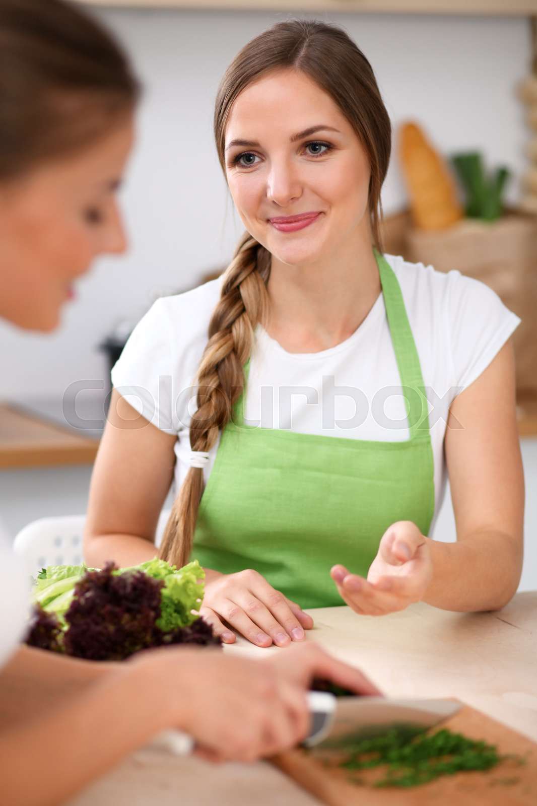 Two women is cooking in a kitchen. | Stock image | Colourbox