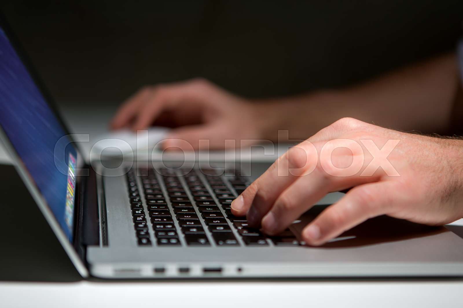 Hand typing on a keyboard of laptop with operating system screen on ...