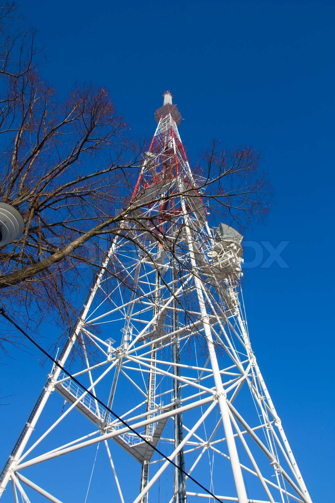 TV mast with microwave link and TV transmitter antennas over a blue sky ...
