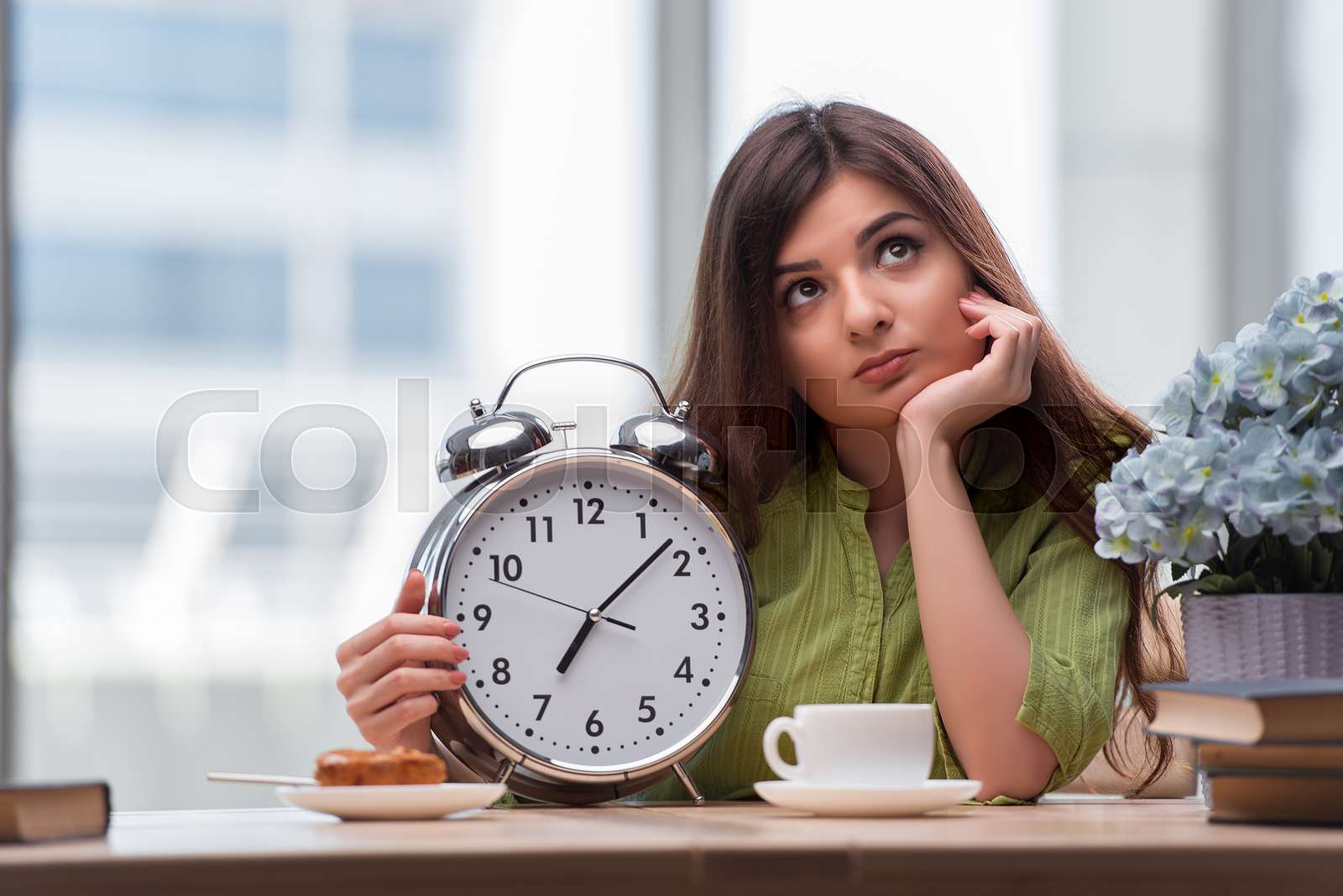 Student with gian alarm clock preparing for exams | Stock image | Colourbox