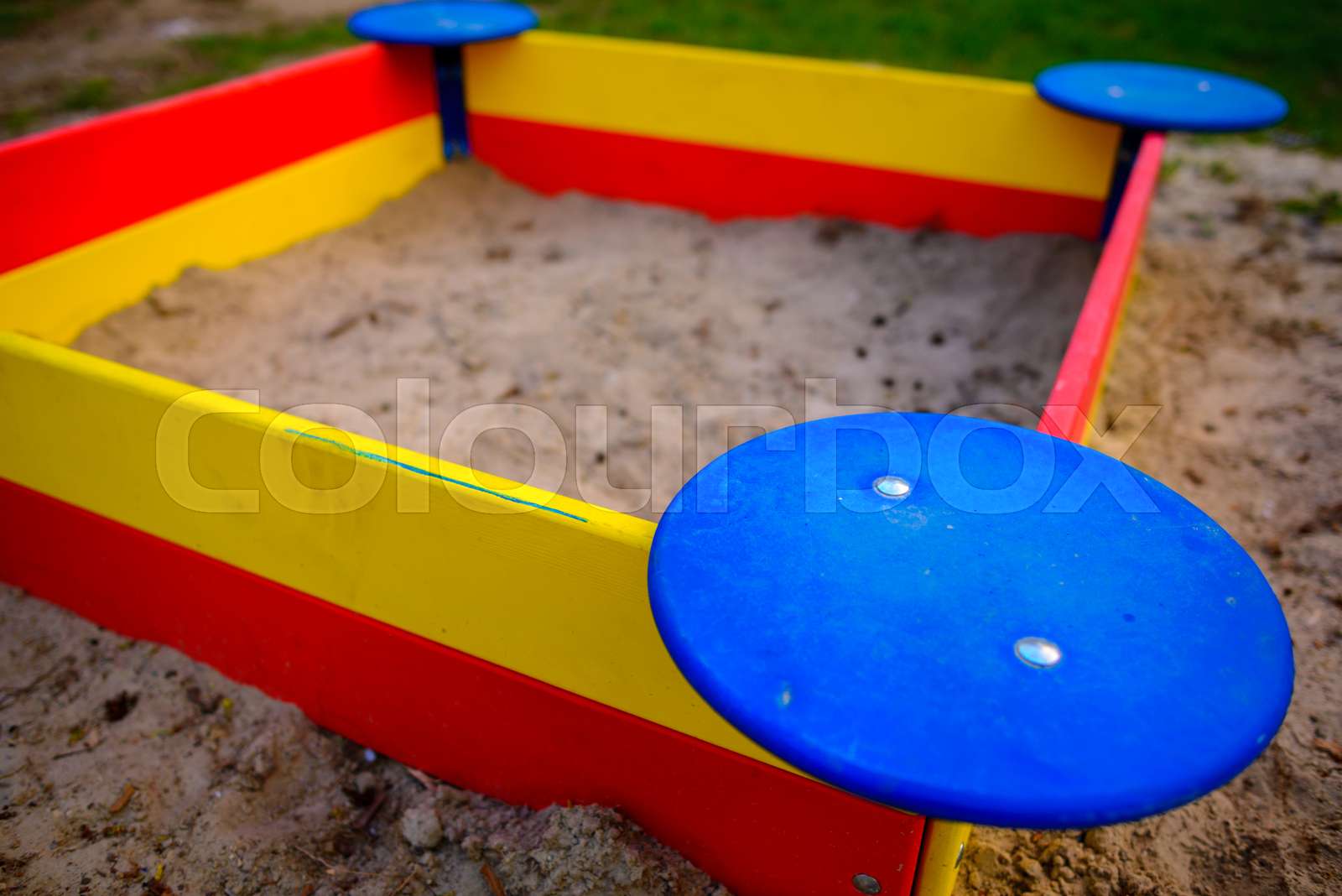 A nice sandbox playground filled . Surrounded by green grass, | Stock ...