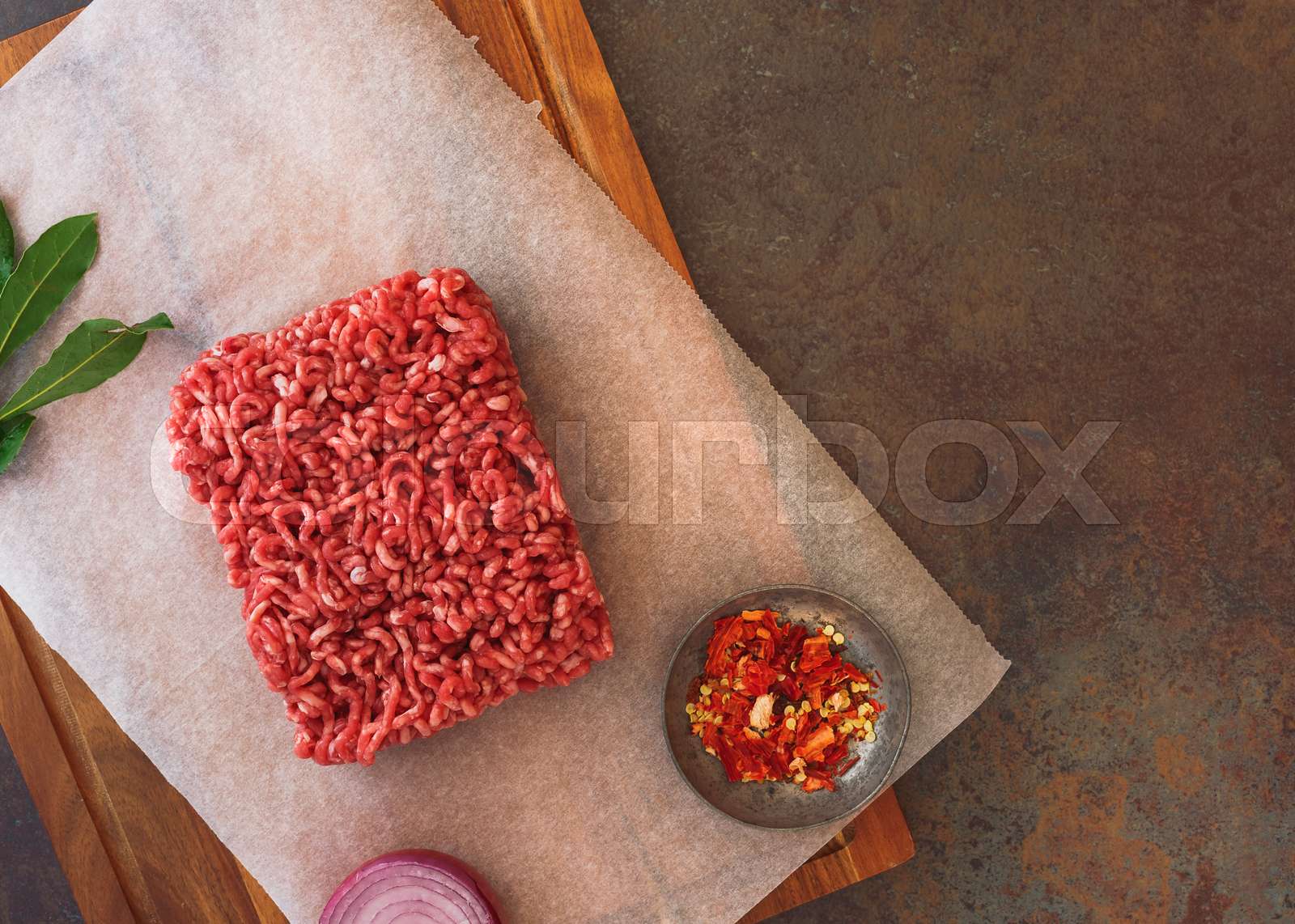 Fresh ground beef and seasonings on butcher paper, ready for cooking ...