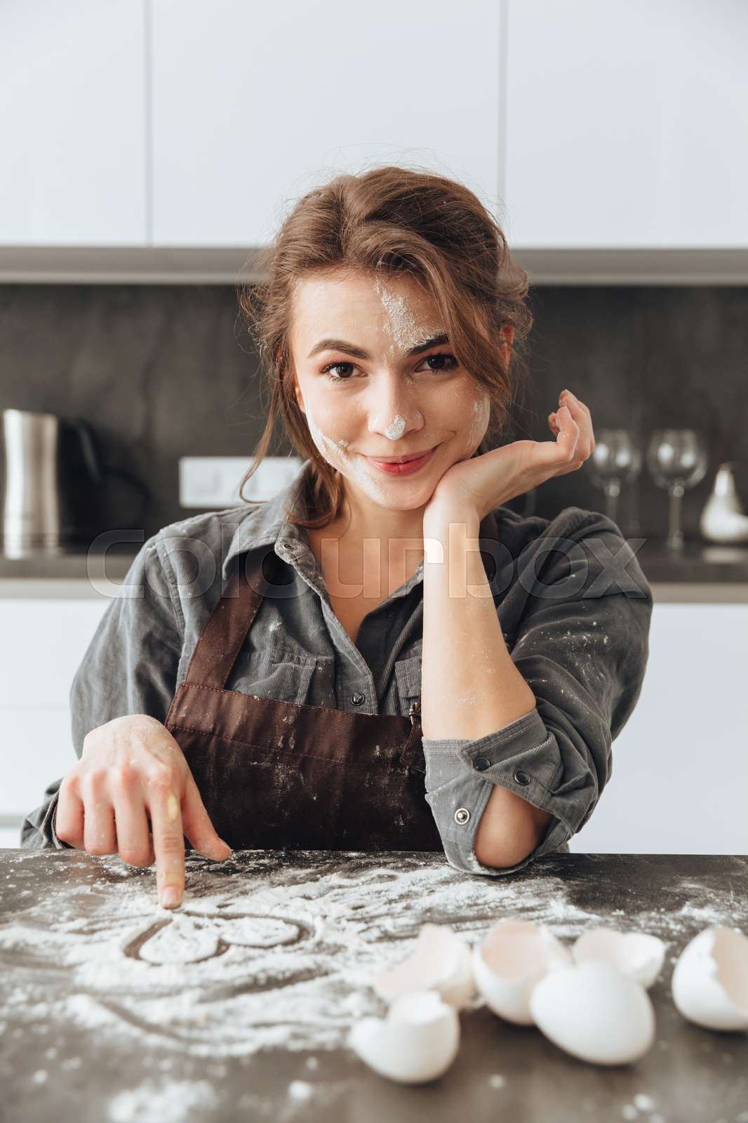 Smiling lady sitting in kitchen while cooking | Stock image | Colourbox