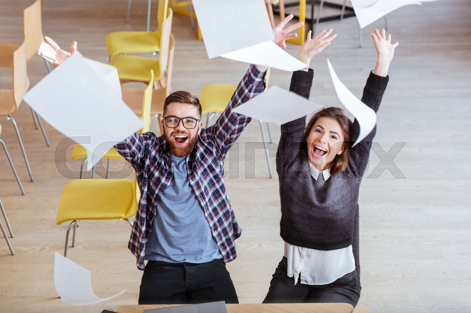 Happy students making mess in library by throwing papers | Stock image ...