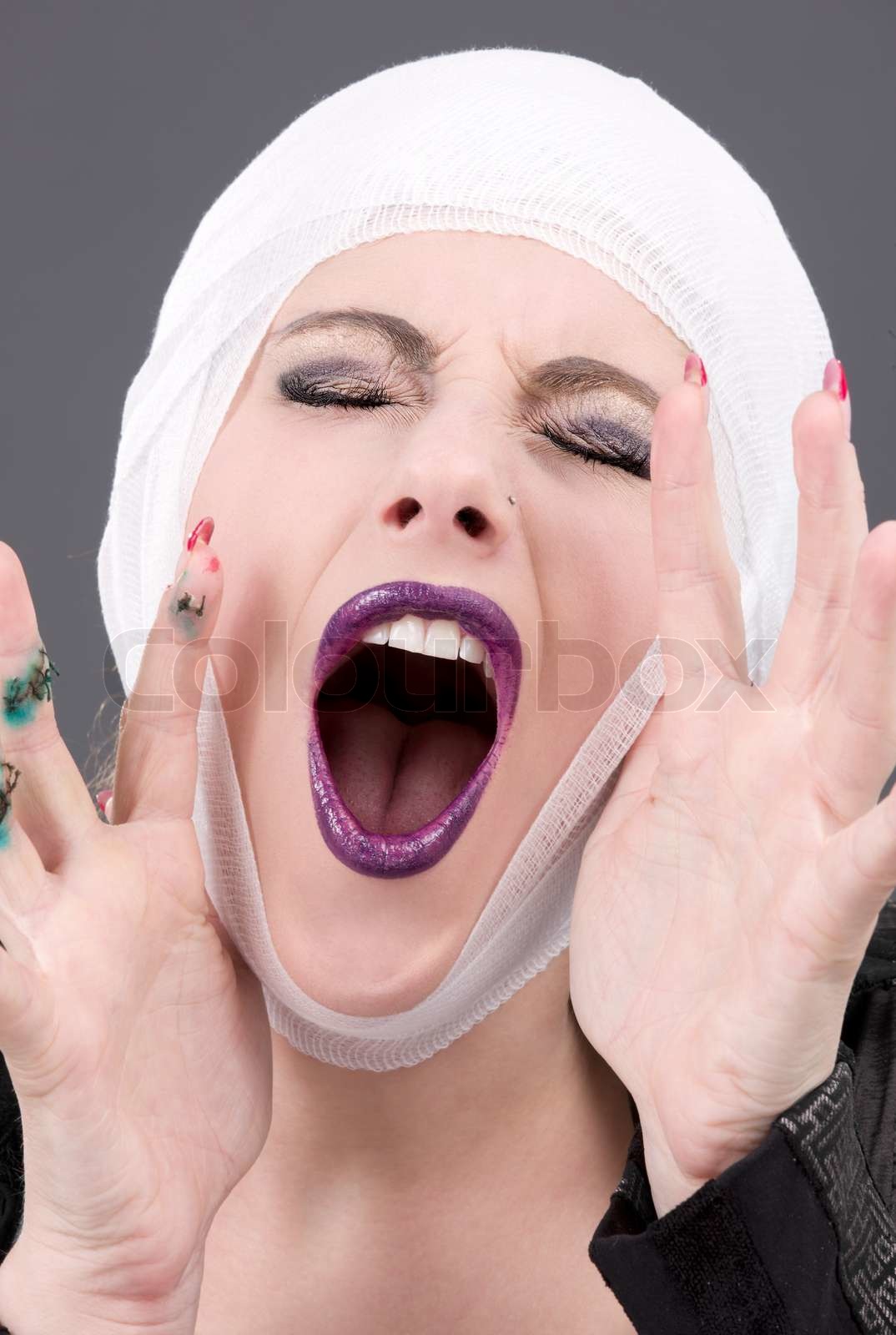 picture of screaming wounded woman face over grey | Stock image | Colourbox