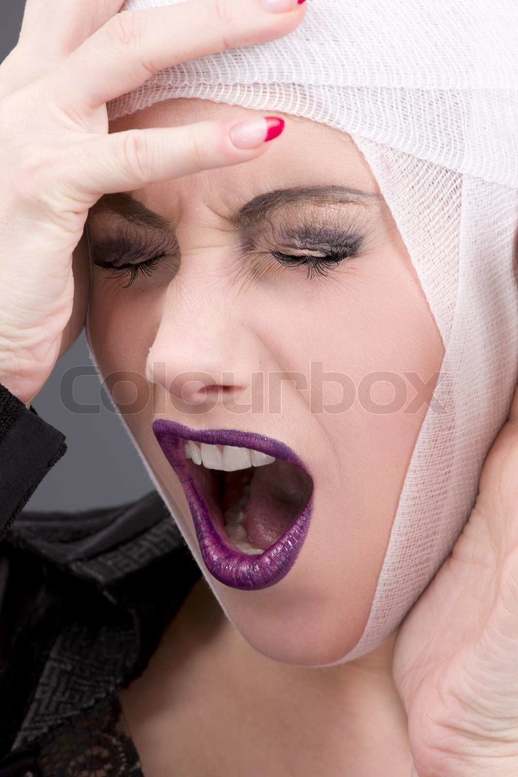 picture of screaming wounded woman face over grey | Stock image | Colourbox