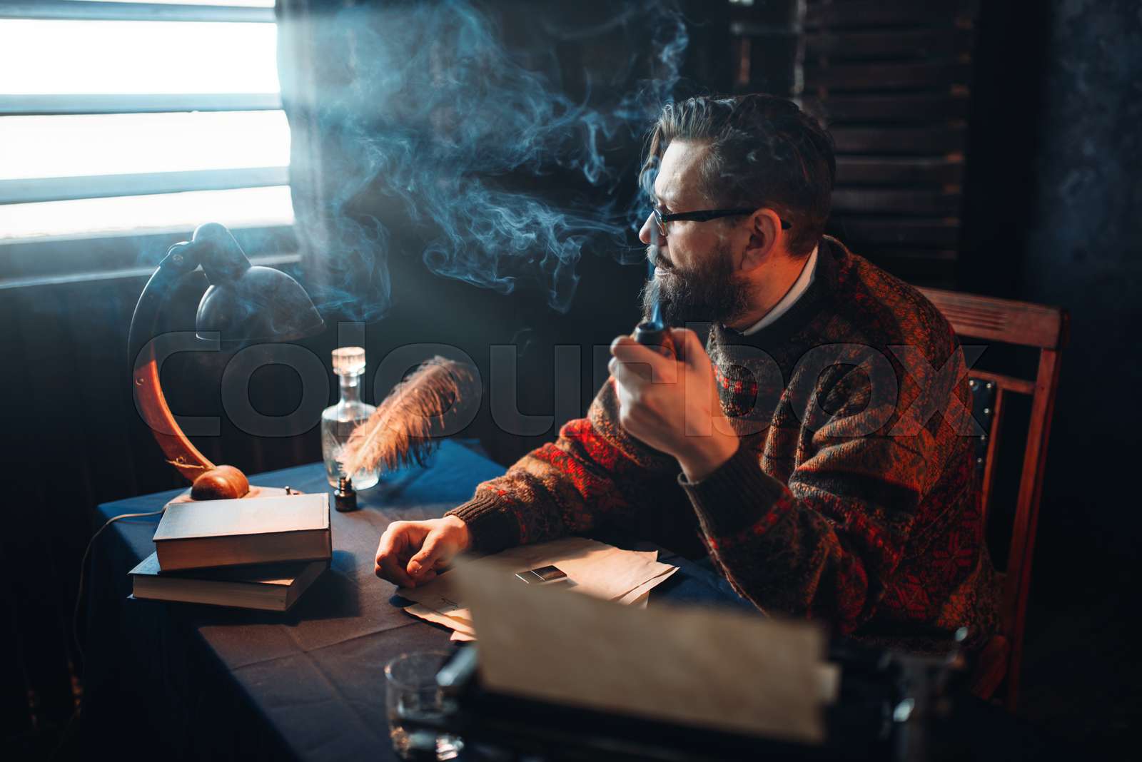 Bearded writer in glasses smoking a pipe | Stock image | Colourbox