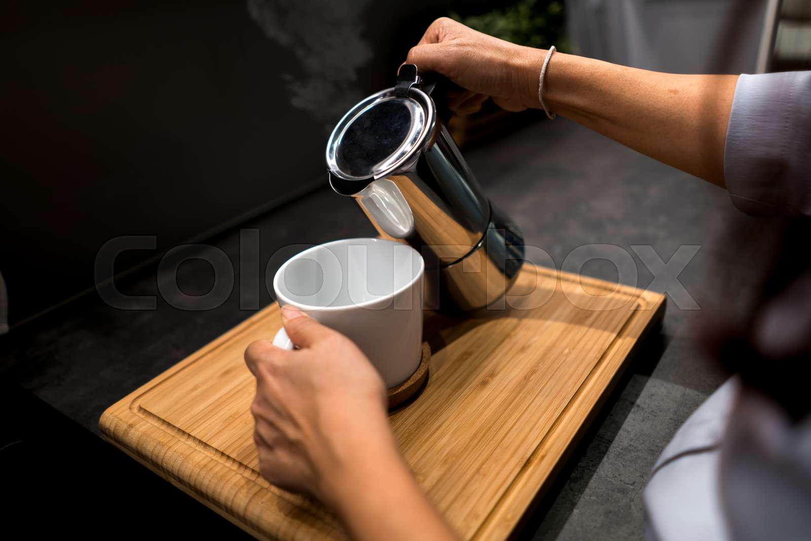 woman holding coffee pot pouring coffee into white cup | Stock image ...