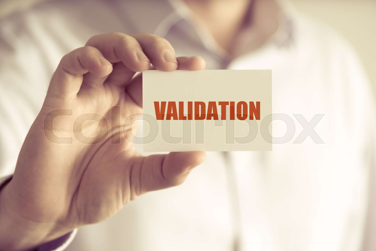 Businessman holding VALIDATION message card | Stock image | Colourbox