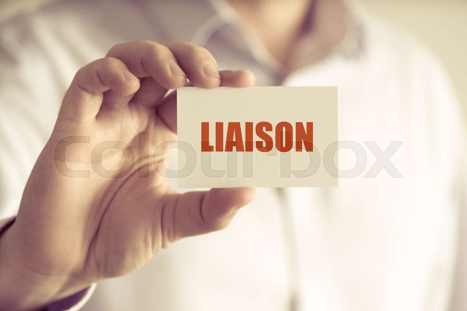 Businessman holding LIAISON message card | Stock image | Colourbox