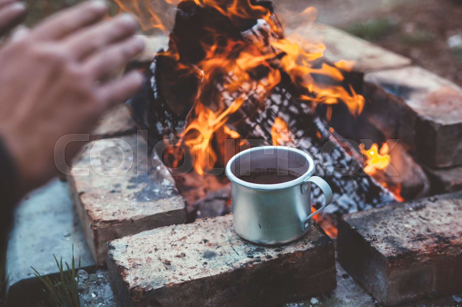 Human warming his hands by the campfire | Stock image | Colourbox