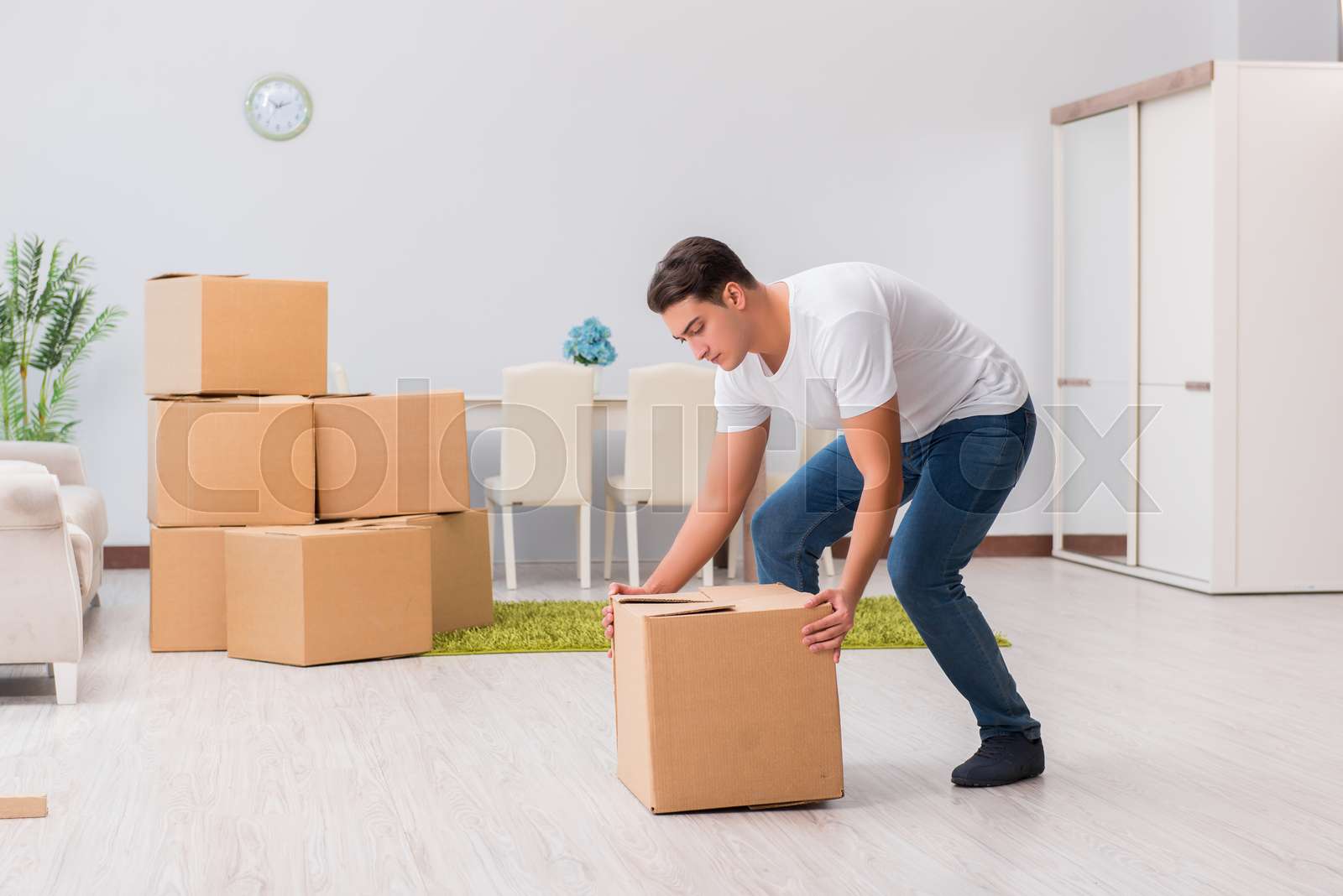 Man carrying boxes at home | Stock image | Colourbox