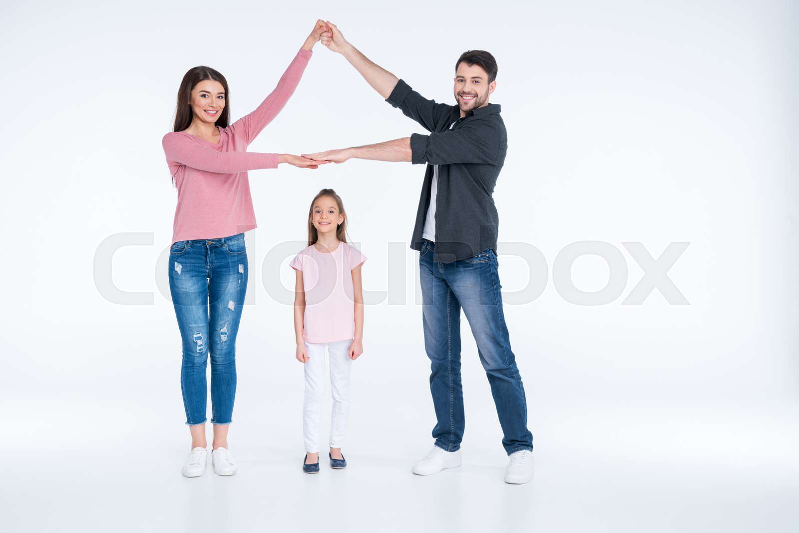 Happy parents holding hands above cute little daughter on white | Stock ...