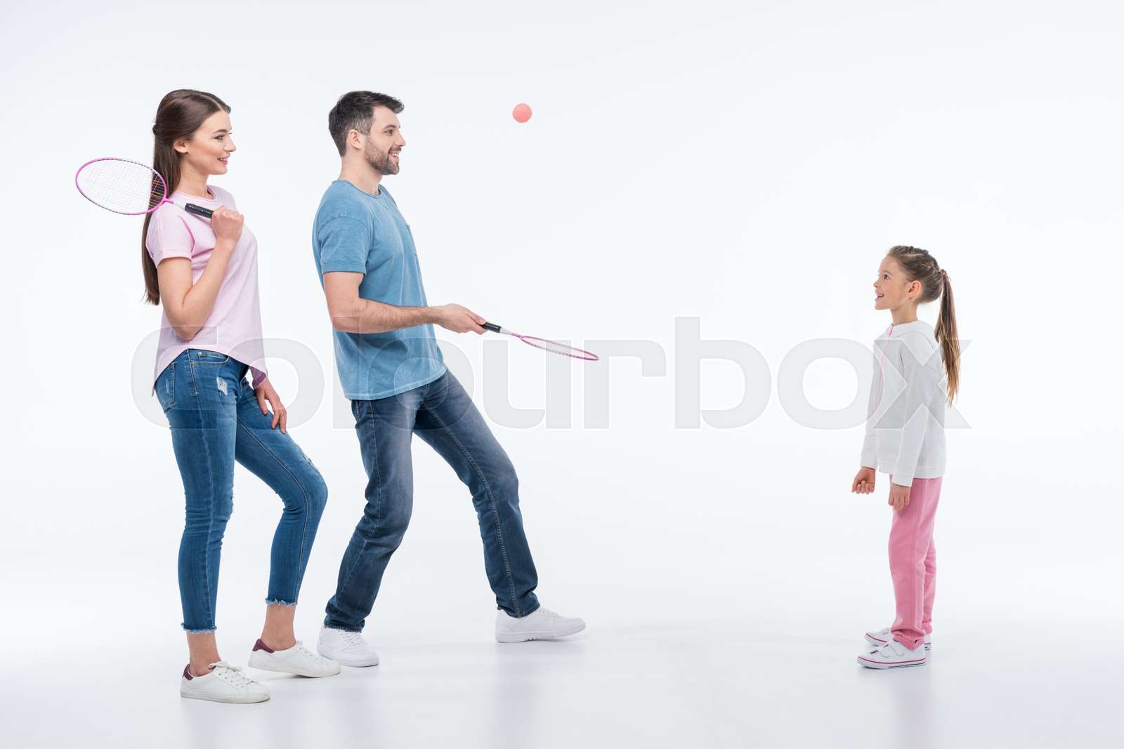 smiling family playing badminton with rackets and shuttlecock on white ...
