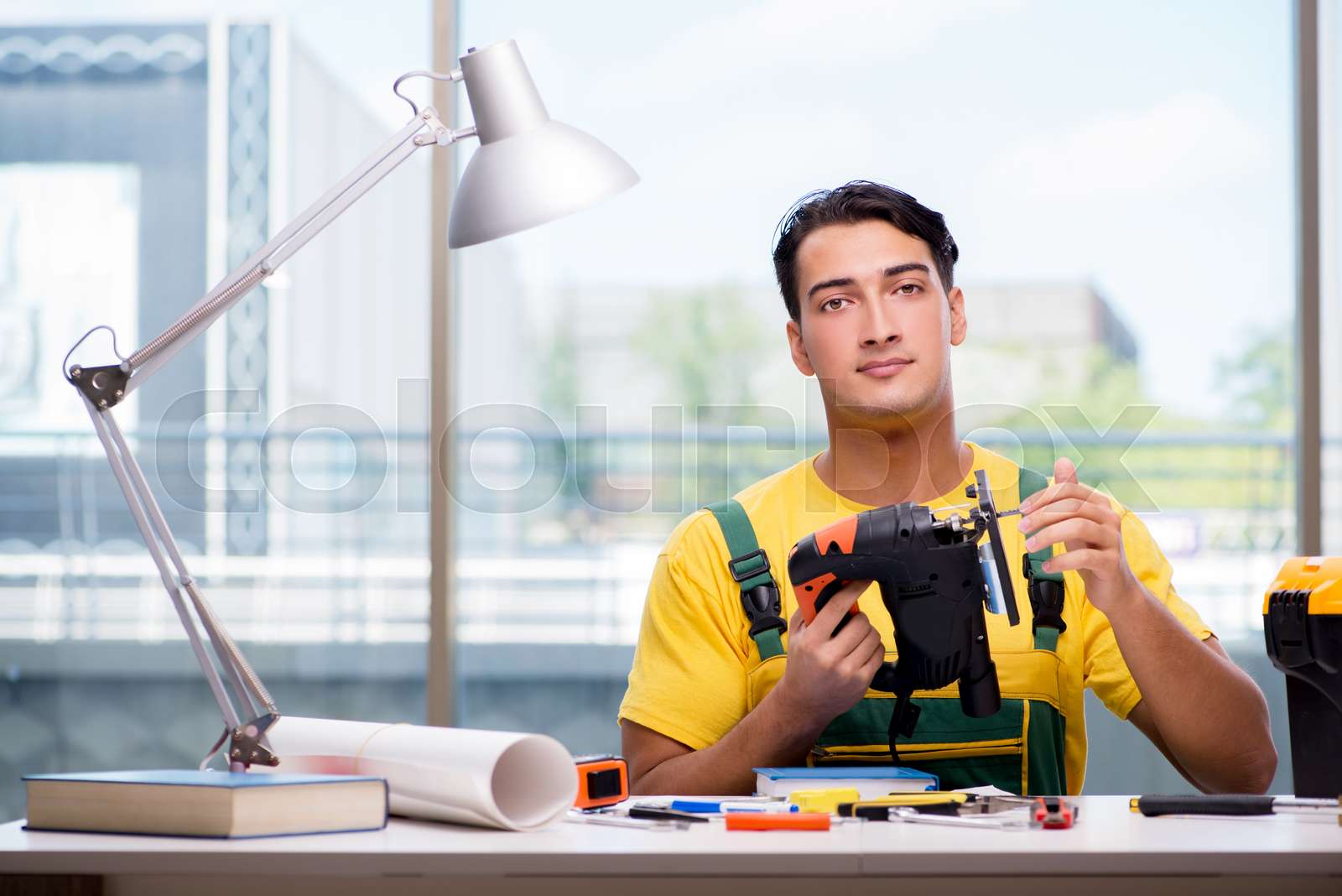 Construction worker sitting at the desk | Stock image | Colourbox
