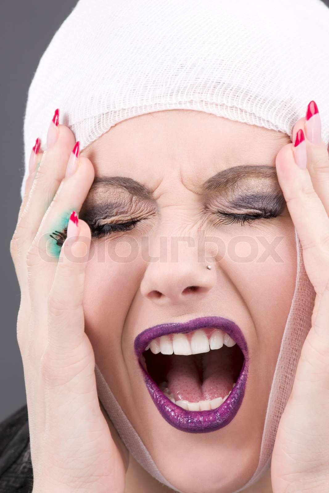 picture of screaming wounded woman face over grey | Stock image | Colourbox