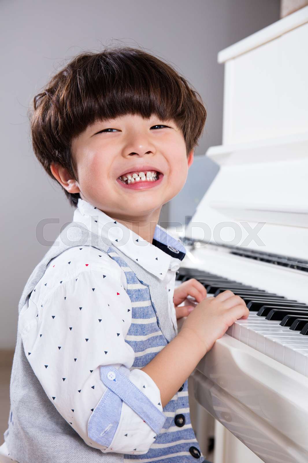 Happy Asian Chinese little boy playing piano at home | Stock image ...