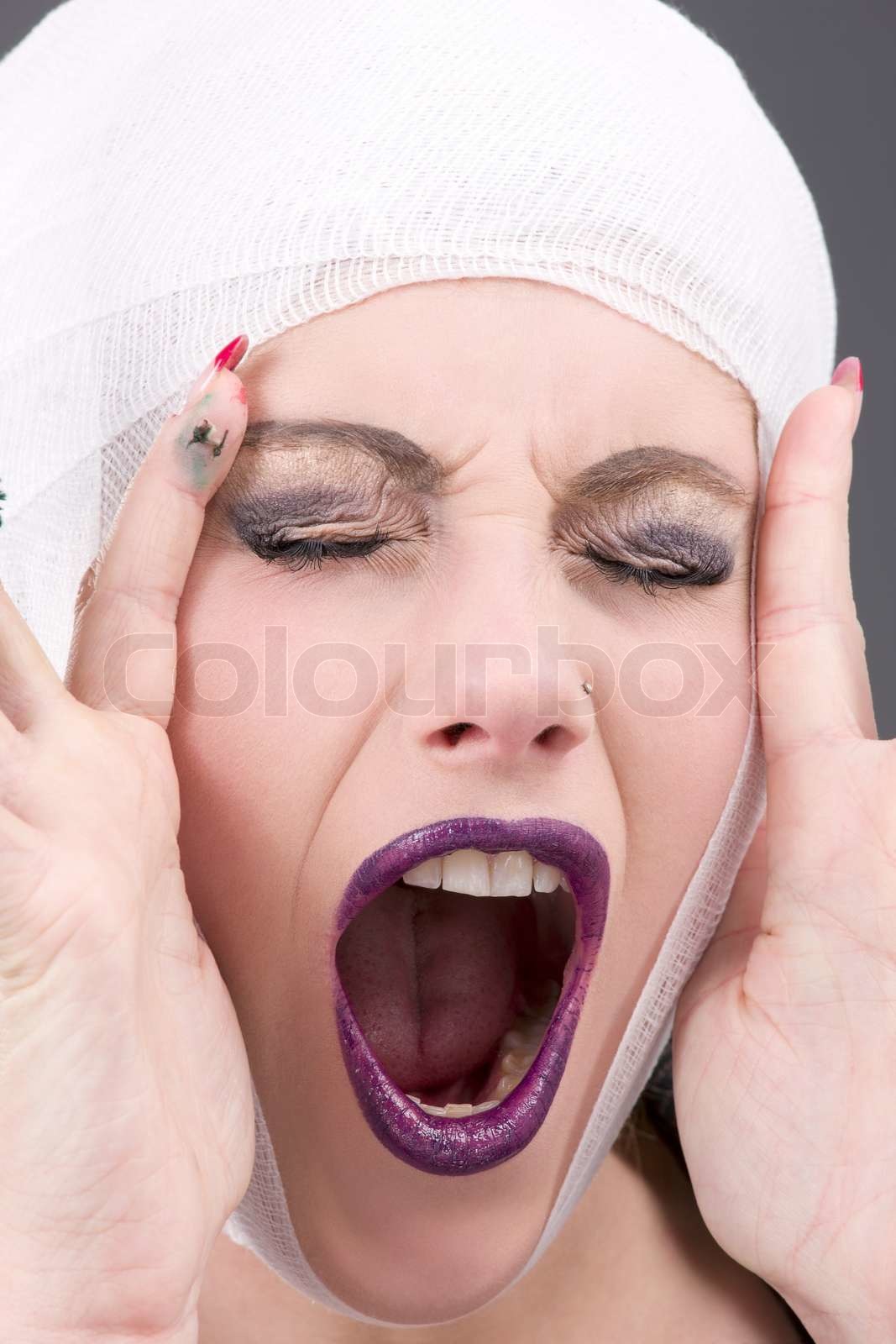 picture of screaming wounded woman face over grey | Stock image | Colourbox