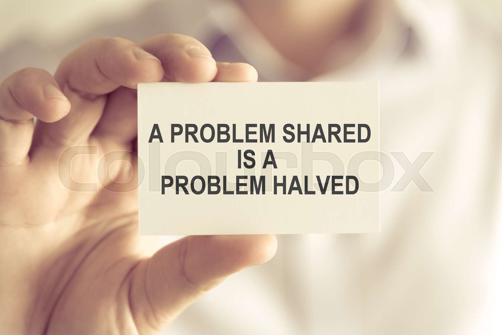 Businessman holding A PROBLEM SHARED IS A PROBLEM HALVED message card ...