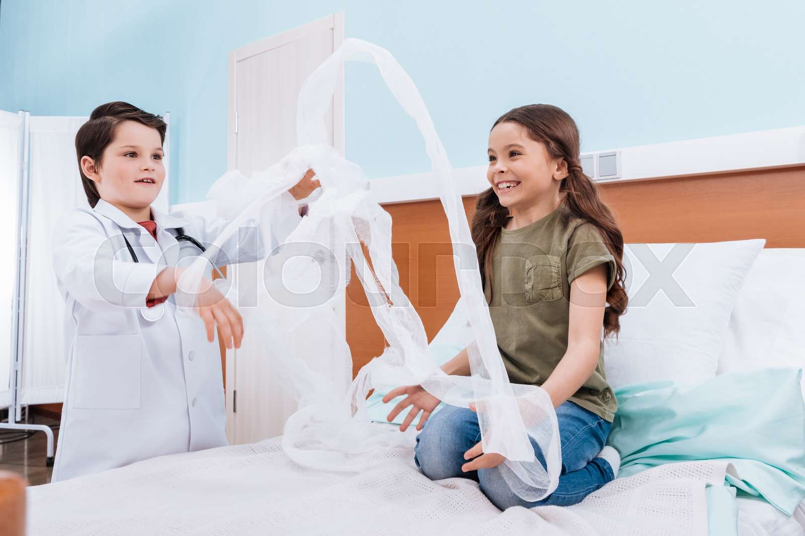 Happy kids playing doctor and patient and having fun with bandage in ...