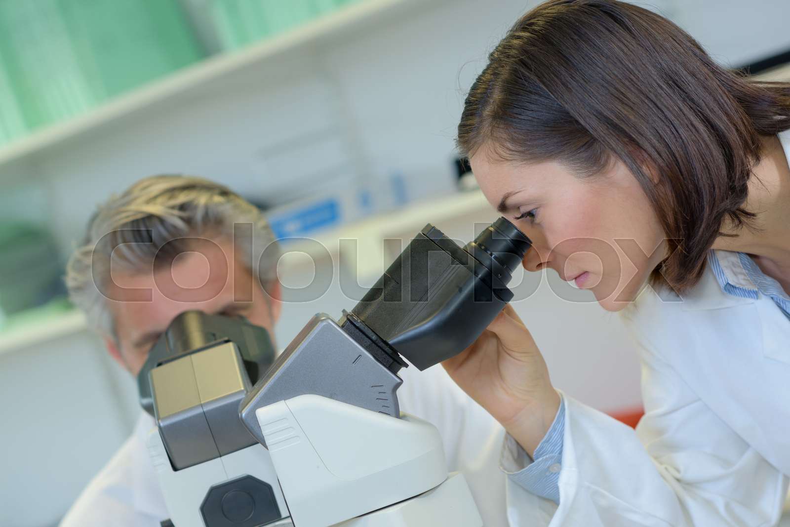 Woman looking into microscope | Stock image | Colourbox