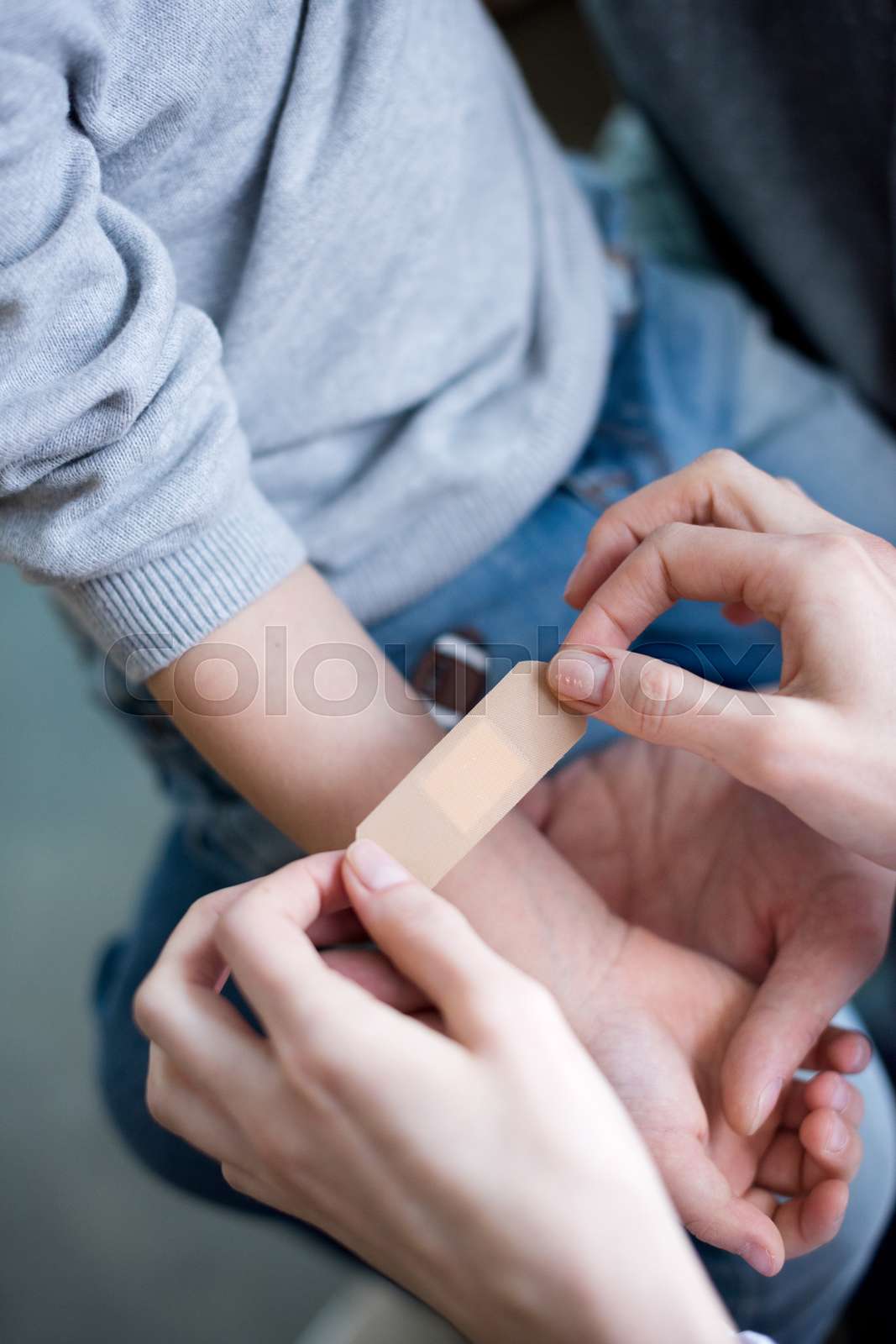 Doctor putting medical patch on hand | Stock image | Colourbox