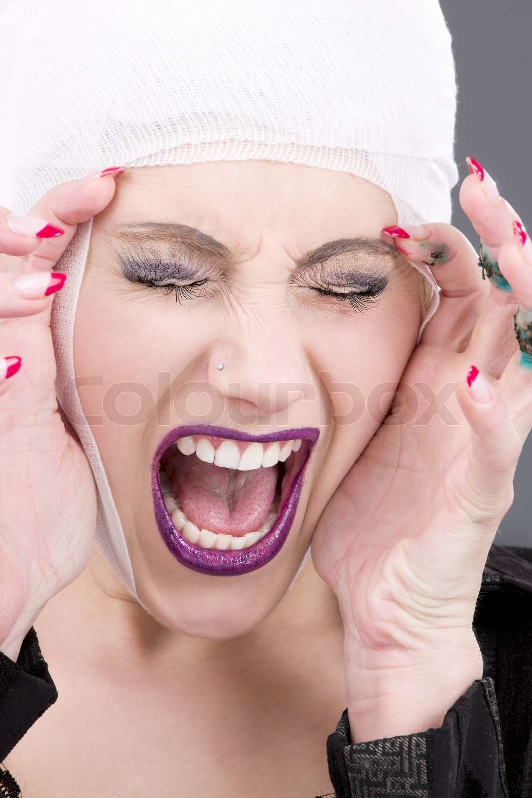 picture of screaming wounded woman face over grey | Stock image | Colourbox