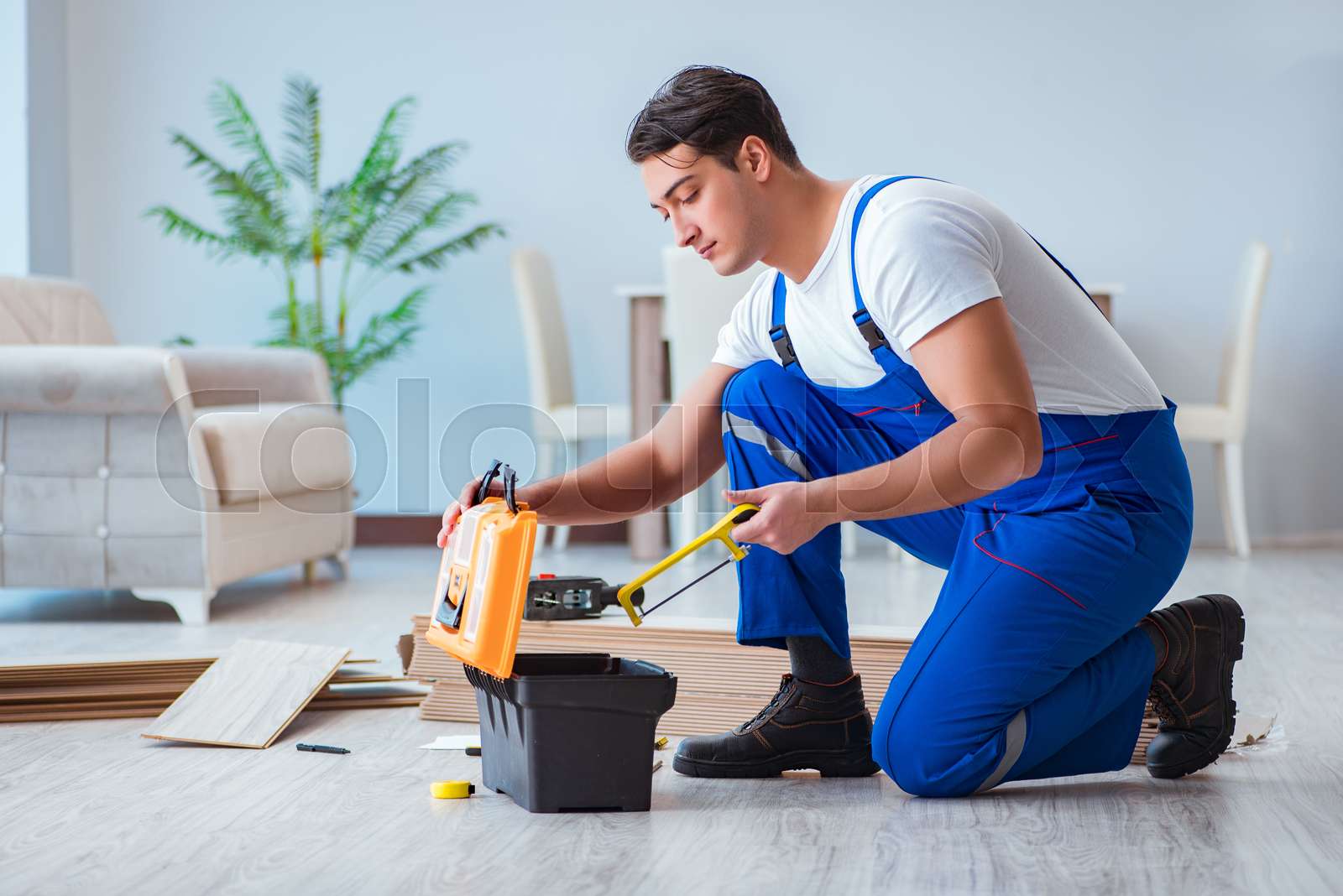 Repairman laying laminate flooring at home | Stock image | Colourbox
