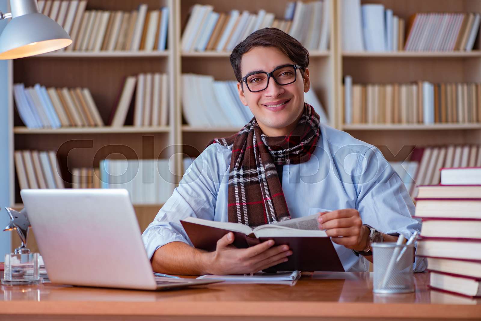 Young book writer writing in library | Stock image | Colourbox