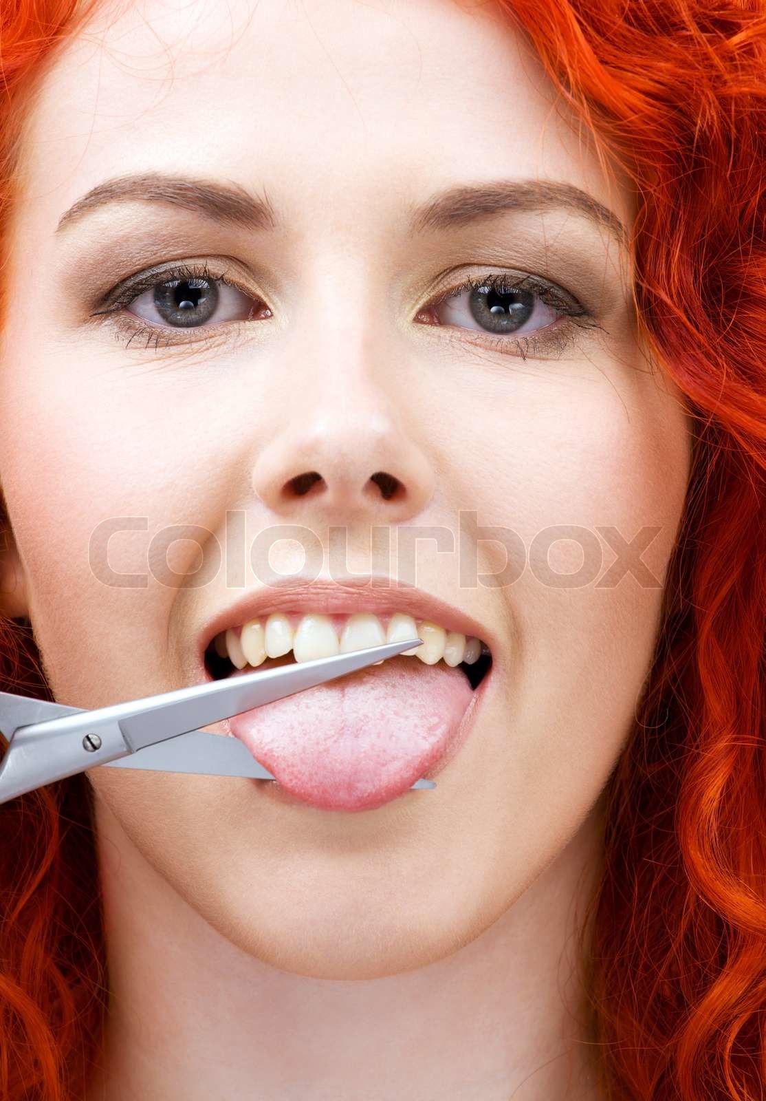 lovely redhead cutting tongue with scissors | Stock image | Colourbox