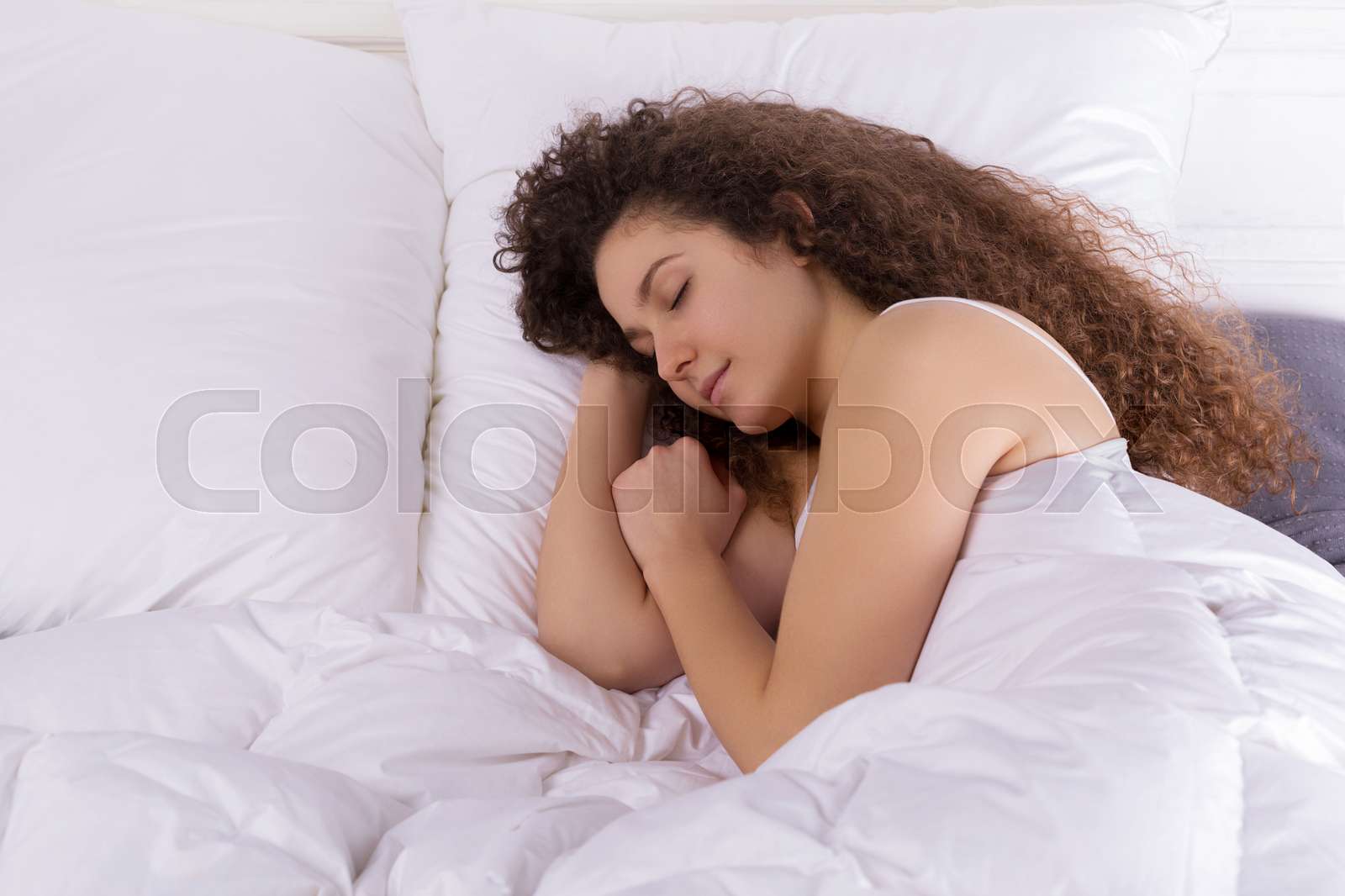 Beautiful girl sleeping in bed alone. | Stock image | Colourbox