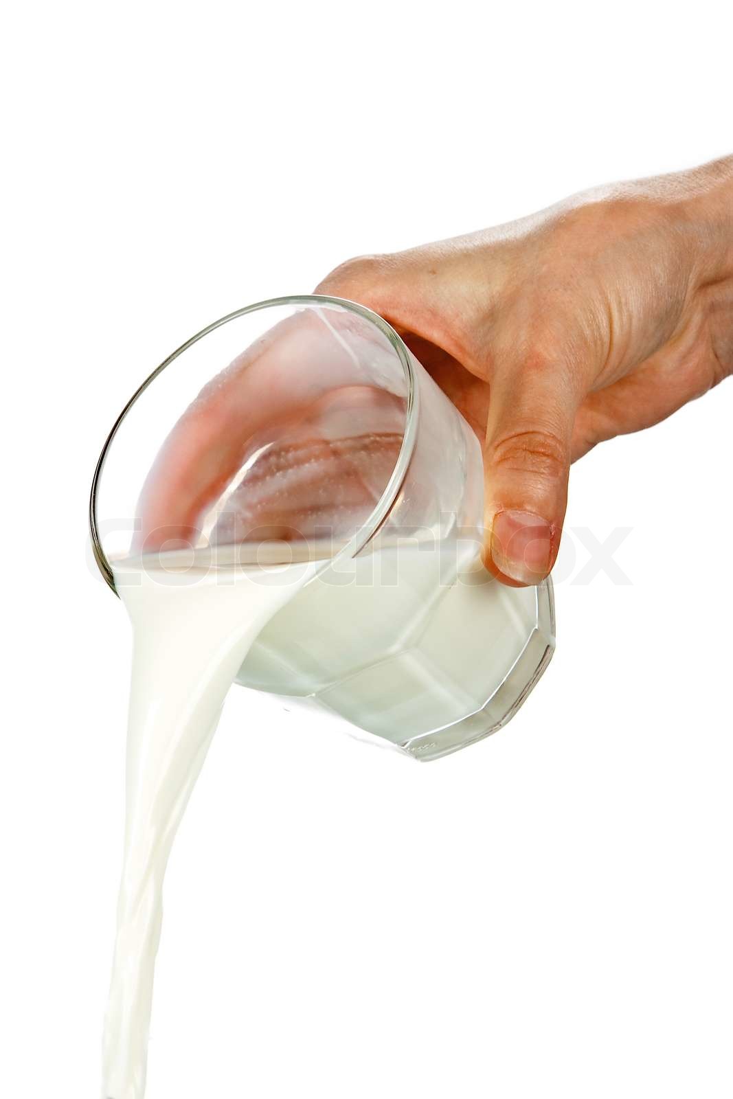 Female hand pouring milk from glass | Stock image | Colourbox