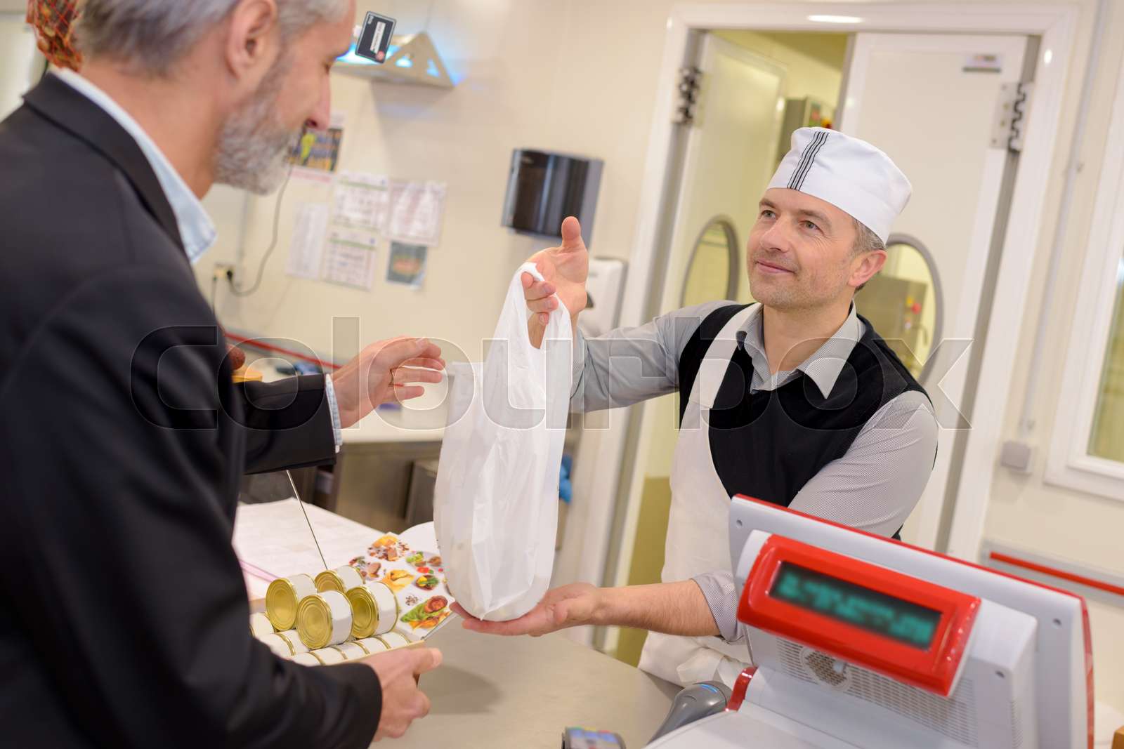 Shopkeeper handing produce to customer in plastic bag | Stock image ...