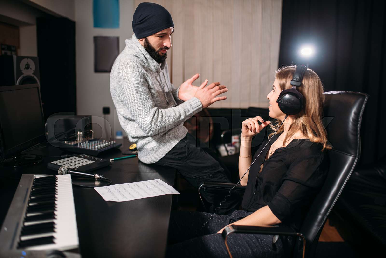 Sound producer with female singer in music studio | Stock image | Colourbox