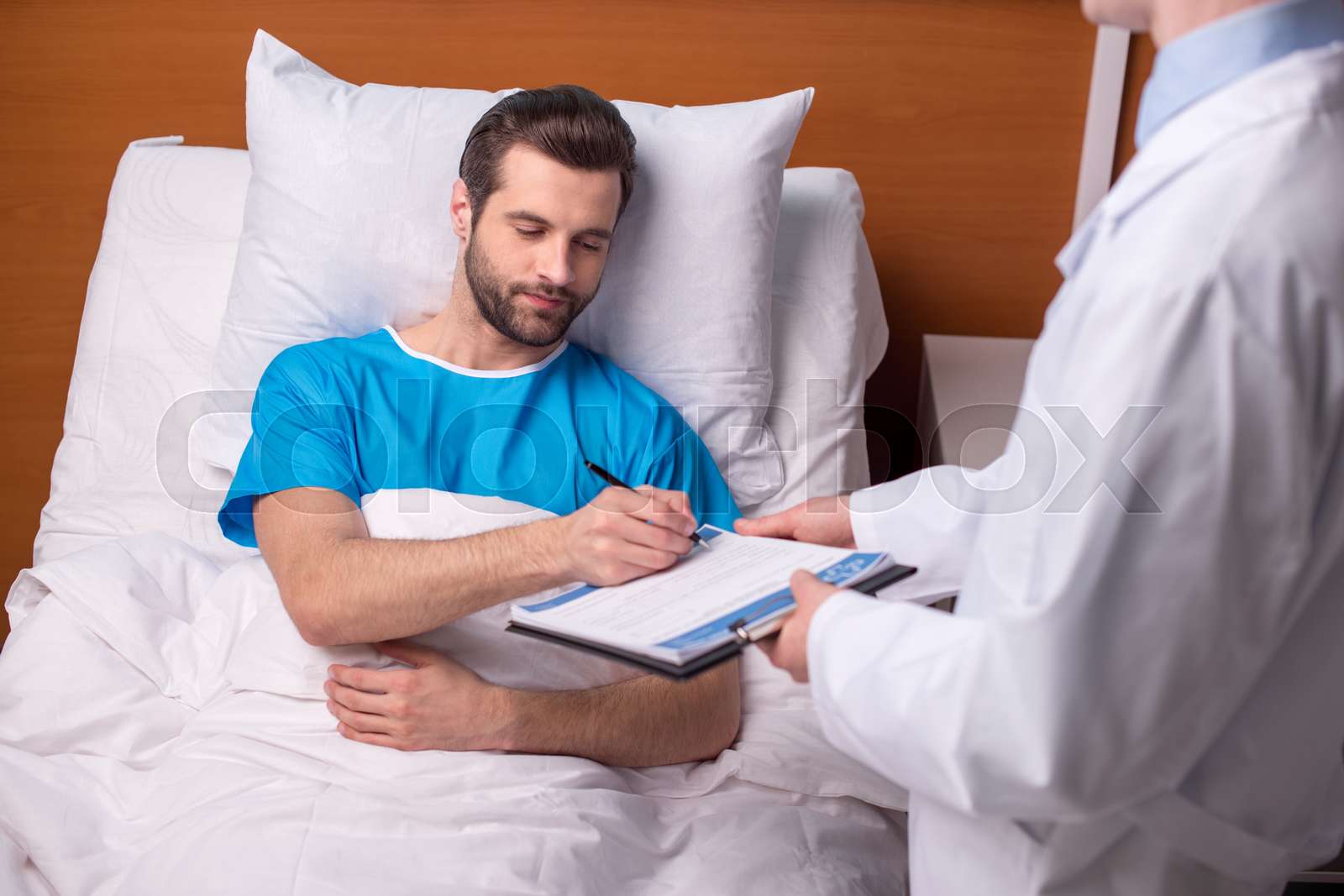 Patient signing medical document | Stock image | Colourbox