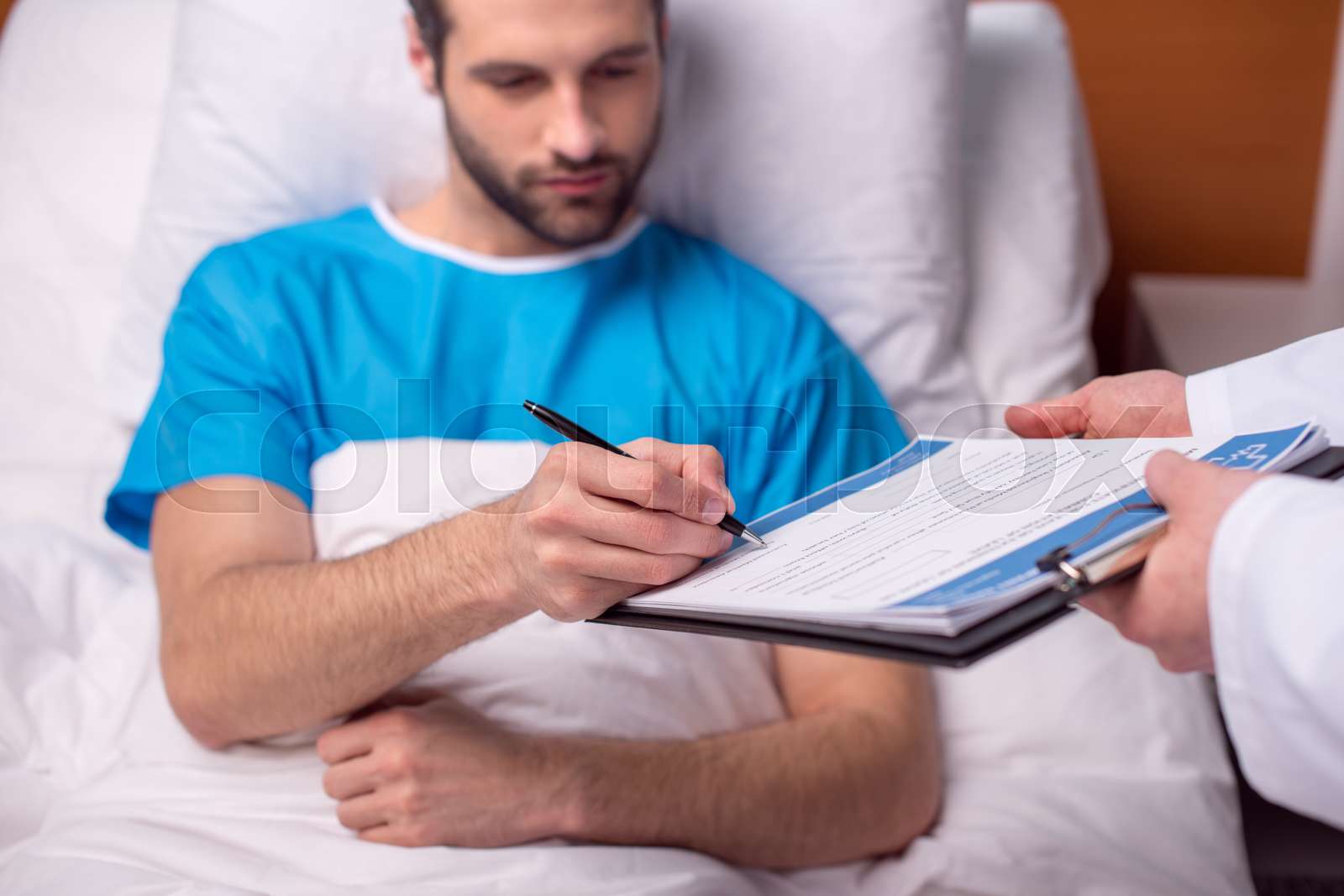 Patient signing medical document | Stock image | Colourbox