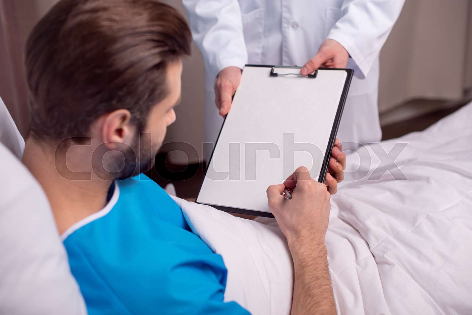 Patient signing medical document | Stock image | Colourbox