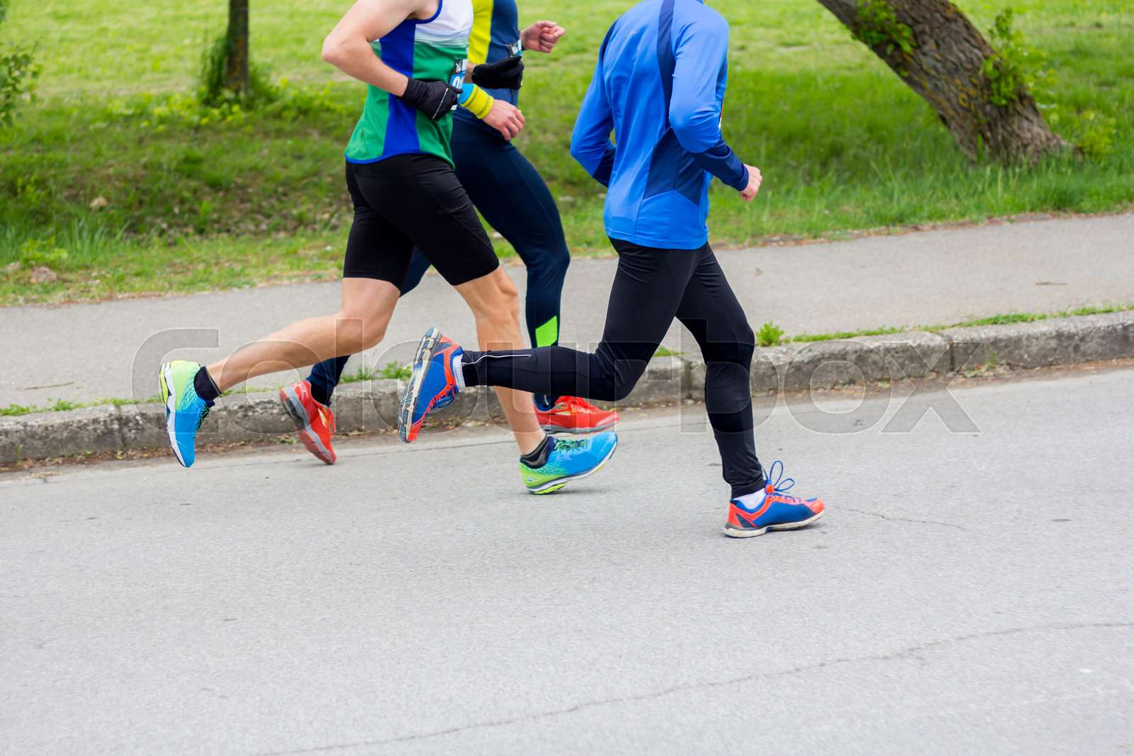 Marathon running race three runners on city road | Stock image | Colourbox