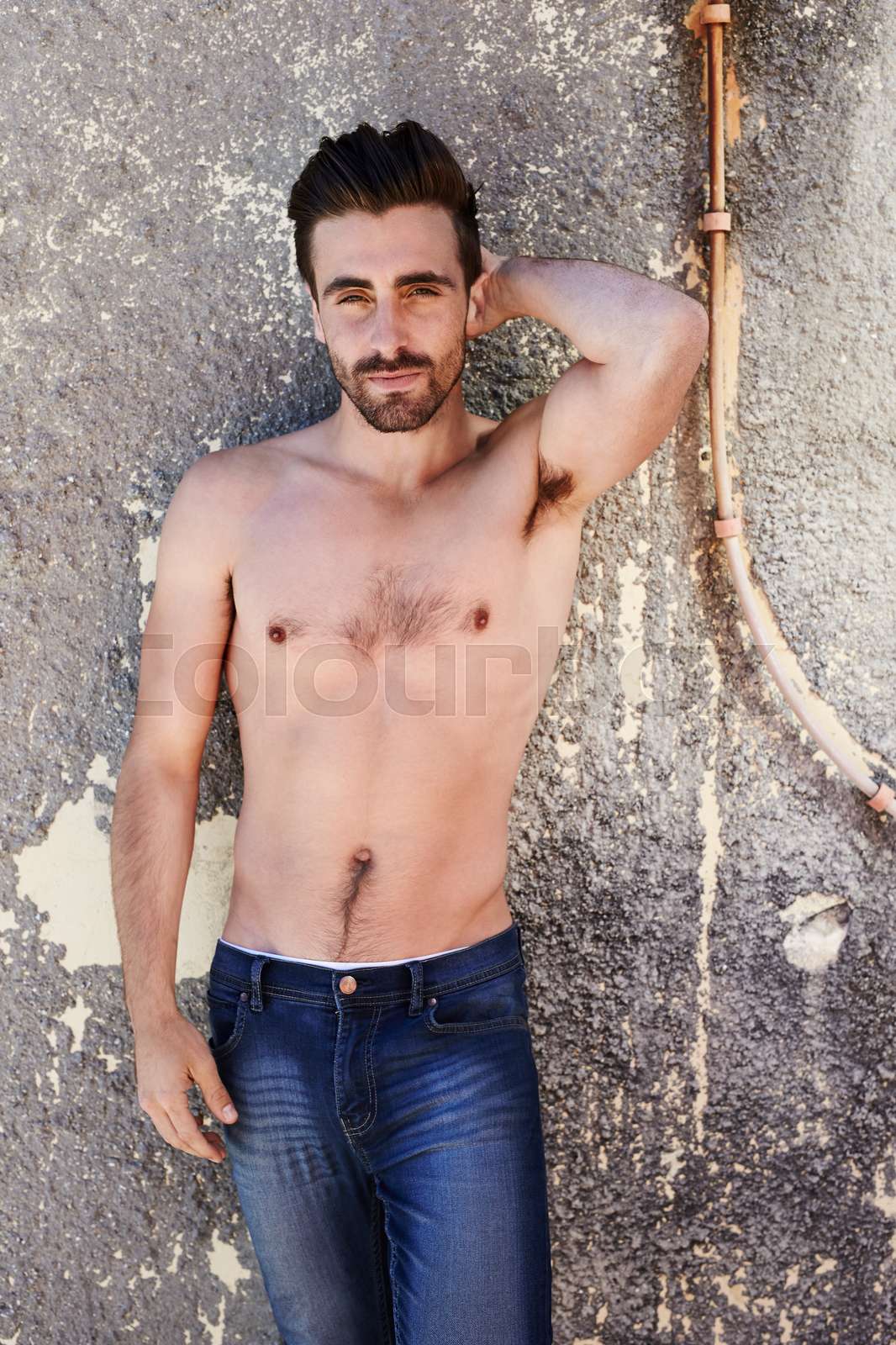Handsome man posing against wall | Stock image | Colourbox