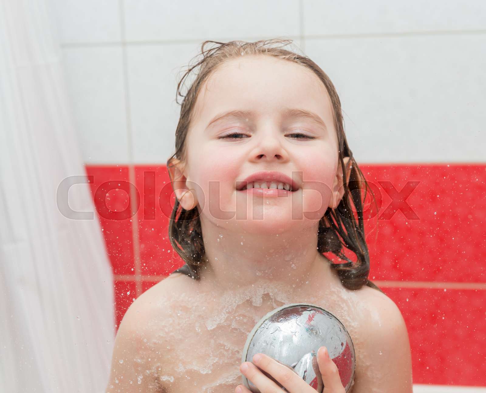 Small child enjoying a shower | Stock image | Colourbox