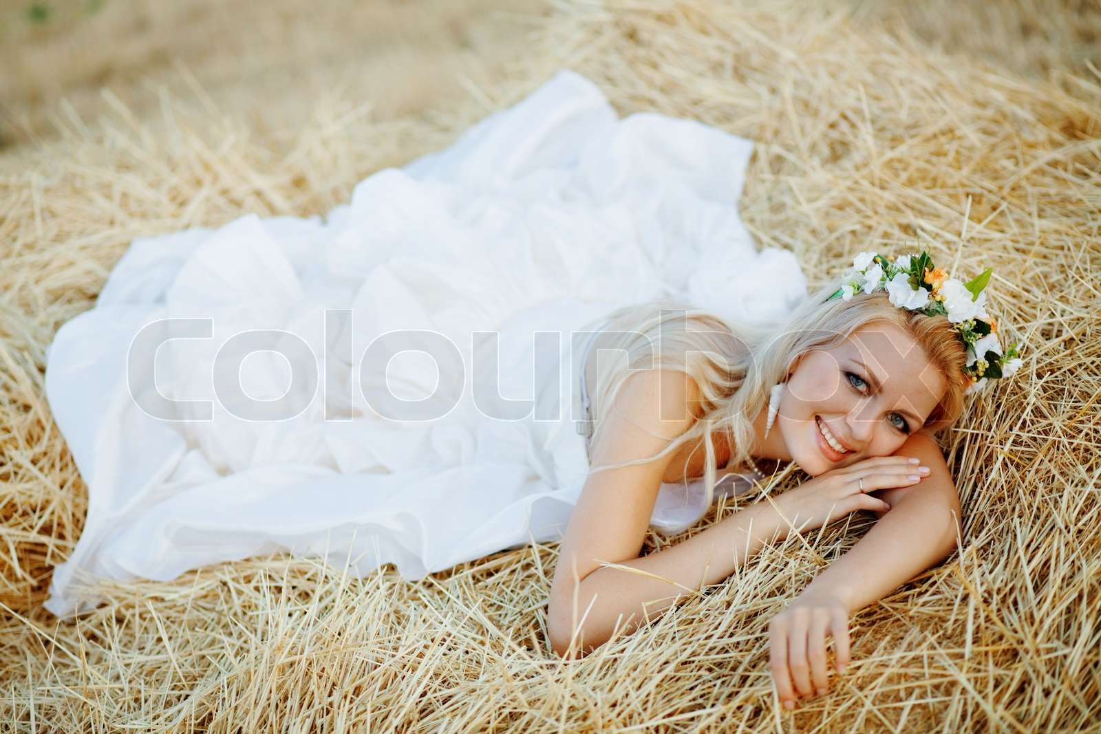 Beautiful bride relaxing in hay stack at her wedding day | Stock image ...