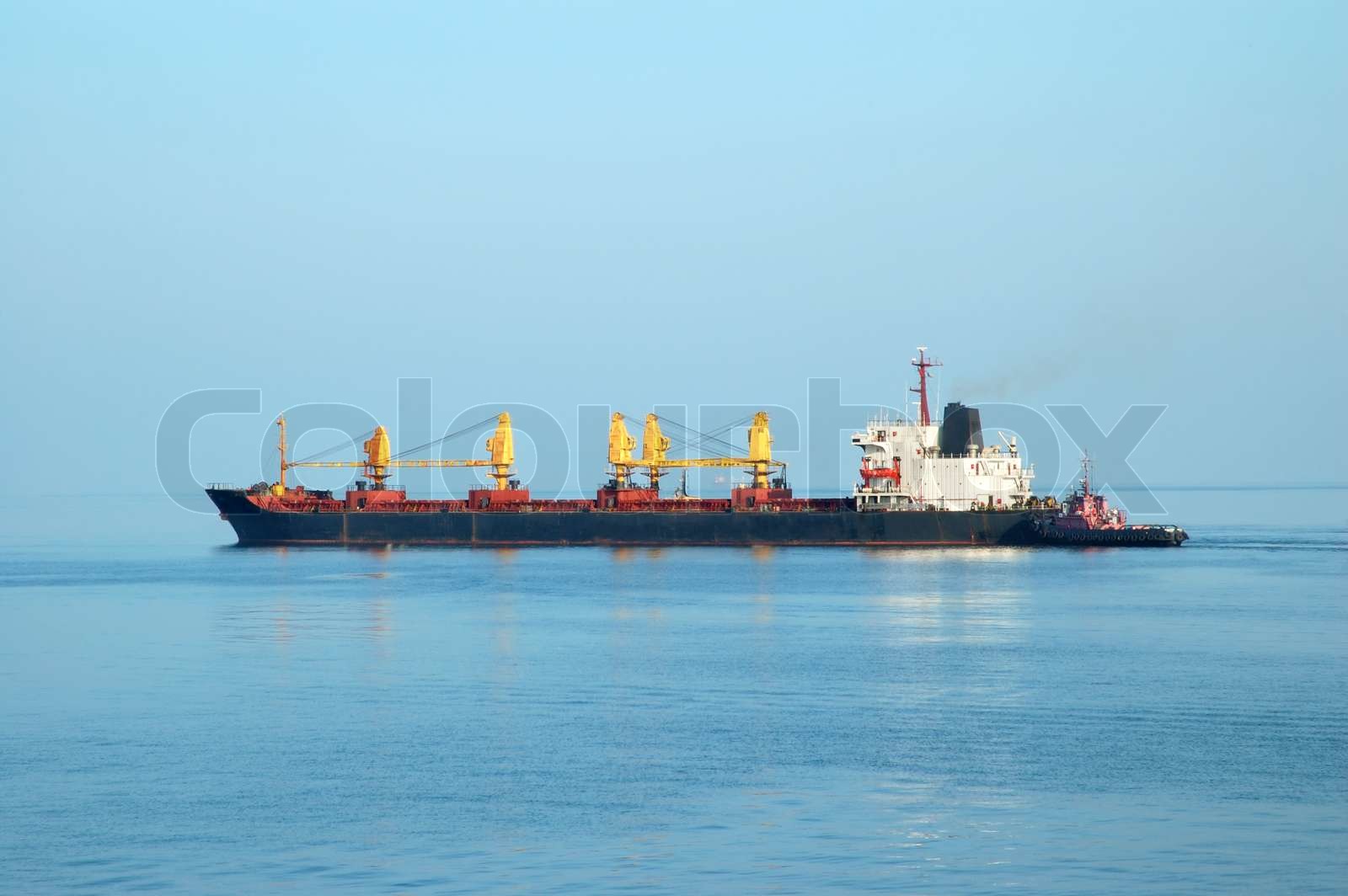 Container ship coming into port with tugboats | Stock image | Colourbox