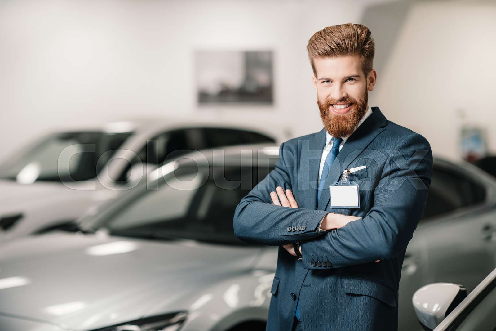 salesman in suit with crossed arms posing and looking at camera in ...