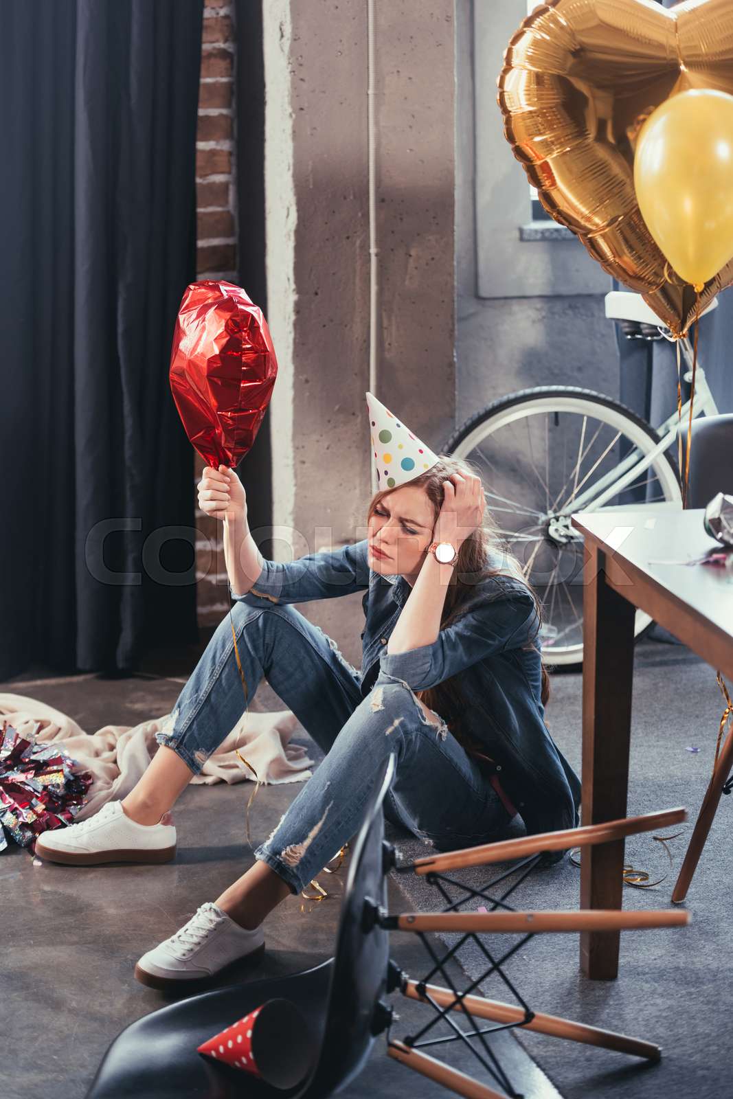 confused young woman holding balloon in messy room after party | Stock ...